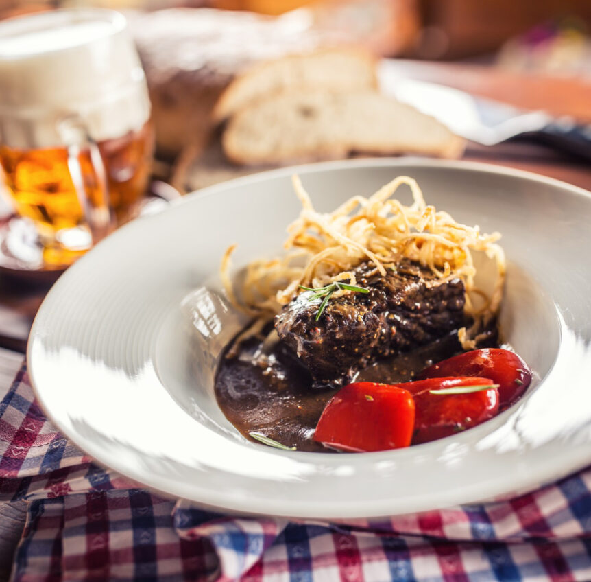 Steak de bœuf confit à la bière et aux oignons, accompagné de pain ...